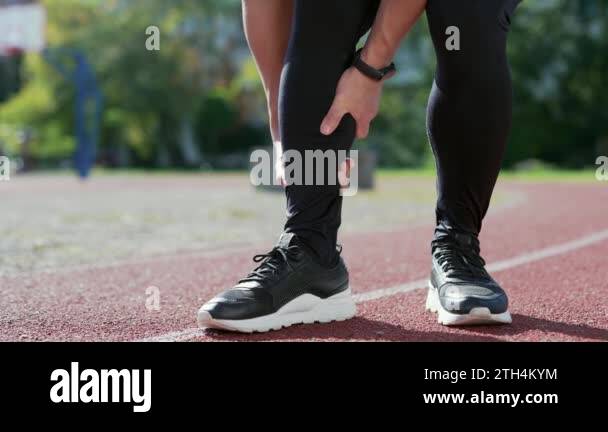 Close up; injured leg of a male athlete at the city stadium. Man ...