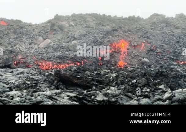 Panorama of steaming black lava rocks. Red hot molten lava flowing ...
