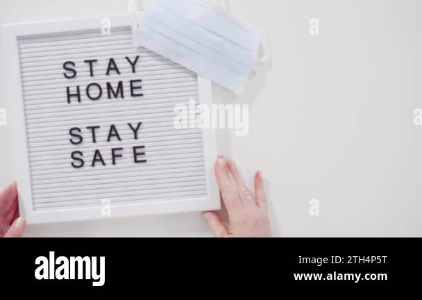 STAY HOME and STAY SAFE sign on message board with a blue medical mask ...
