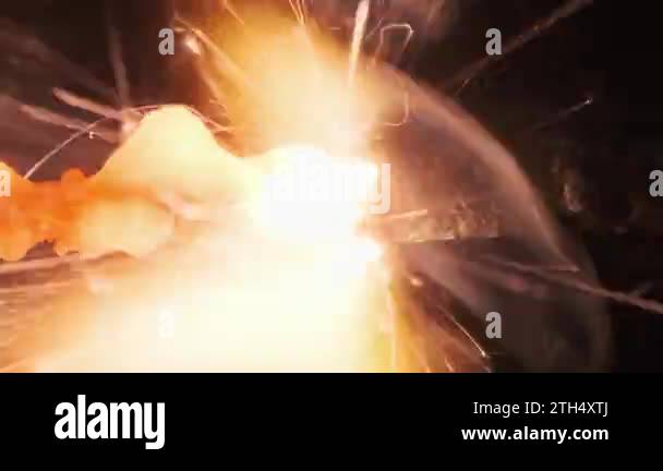 Vertical video, sparkler on the black background in slow motion, macro ...