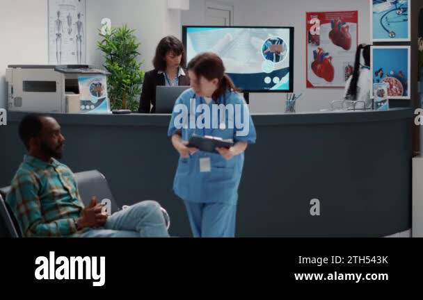 Busy reception desk with many patients coming to fill in report ...
