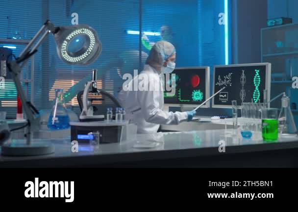 Medical development laboratory. A female scientist types on a keyboard ...