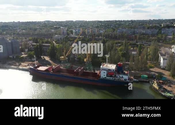 Grain transshipment from container to ship cargo holds with dual scoop ...