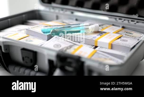 Chemical poisonous drug in flask on packs with dollars in suitcase ...