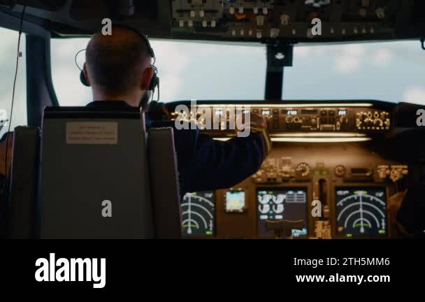 Male airline captain fixing altitude and longitude buttons, using ... Male airline captain fixing altitude and longitude buttons, using ...