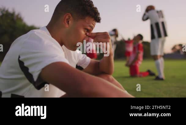 Video of sad biracial football player siting on field. Male football ...