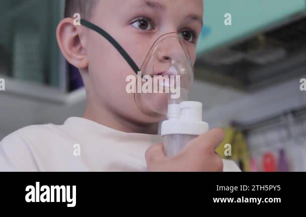 Close-up of an inhaler on the face of a young boy. Treatment for ...