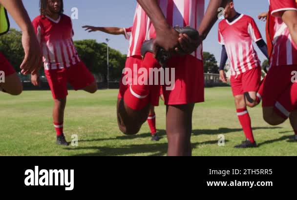 Video of diverse group of male football players warming up on field ...