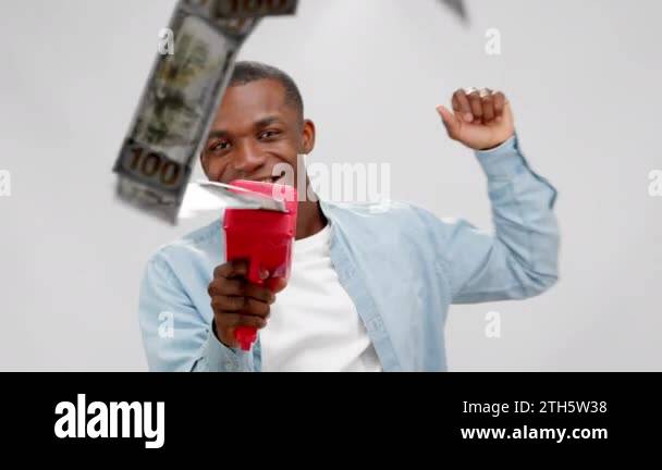 Happy and smiling African-American man dances shooting money because ...