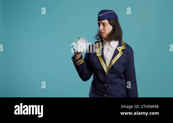 Stressed air hostess checking time on clock in studio, feeling worried ...