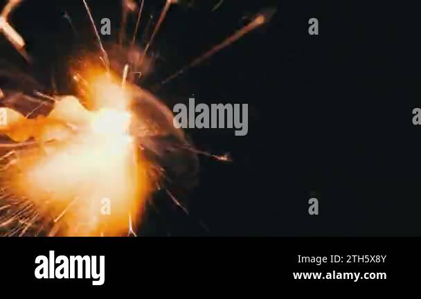 Vertical video, lightening sparkler on black background in slow motion ...