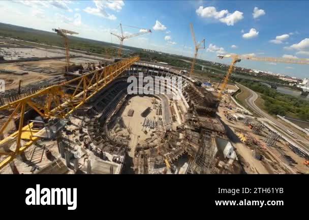 Assembling sports stadium with high cranes and professional workers at ...