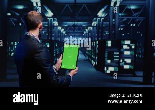 Database Admin Analyzing Greenscreen Display On Tablet Doing Web System Check In Server Room