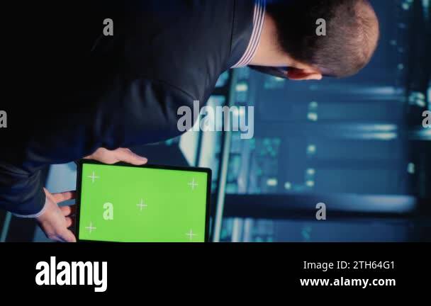 Vertical video: Data center technician holding tablet with green screen ... Vertical video: Data center technician holding tablet with green screen ...