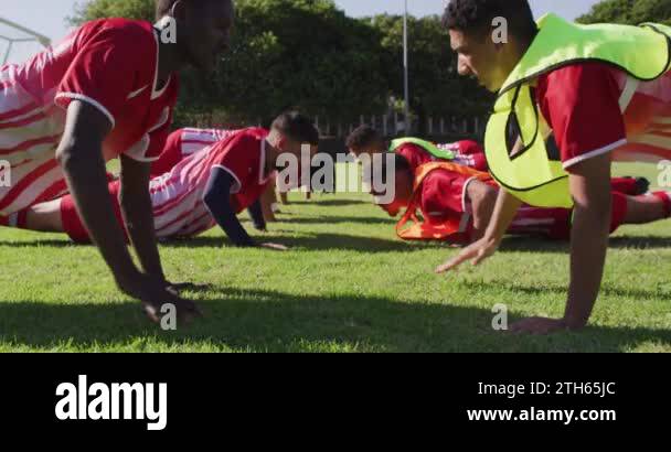 Video of diverse group of male football players warming up on field ...