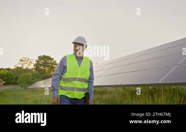 Male ecological engineer walking at the green energy place and collects ...