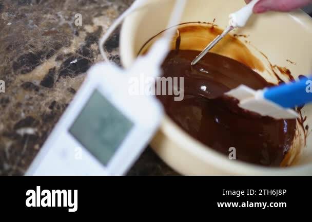 Close-up shot of unrecognisable chocolatier stirring melted chocolate ...