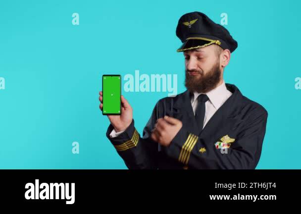Smiling male aviator using telephone with greenscreen, holding ...