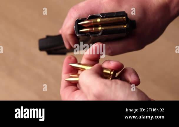 Male hands loading Kalashnikov assault rifle magazine with cartridges ...