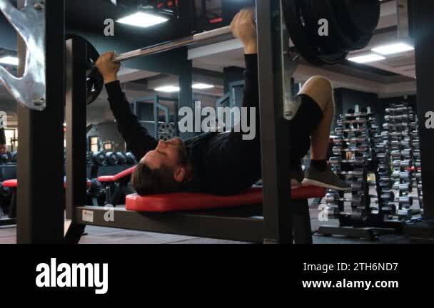February 21, 2023 Ukraine, Dnipro.Barbell bench press. A young athlete ...