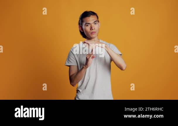 Young adult doing t shape symbol on camera, showing break or pause sign ...