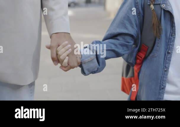 Close up shot of childs hand reaching for mothers loving hand. Parent and daughter holding hands ...