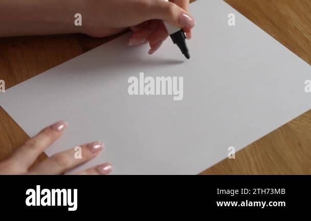 Girl on a white sheet draws a question mark with a black marker ...