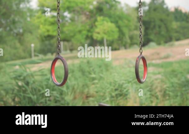 Gymnastic rings made of metal on courtyard sports ground. They swing in ...