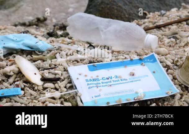 Ocean plastic pollution. Used medical face mask and COVID-19 test on ...