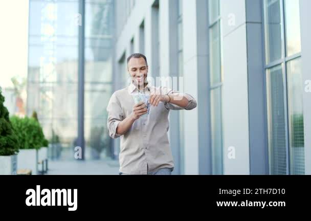 Excited crazy young adult man throwing dollar bills in the air while ...