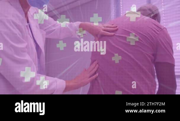 Multiple medical symbol floating against doctor examining back of ...