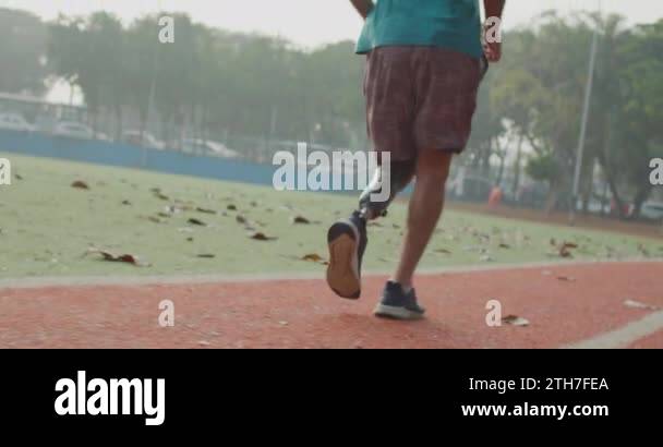 Disabled Athlete running with prosthetic leg at running track ...