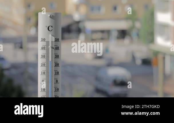 Thermometer with traffic in the background shows increasing temperature ...