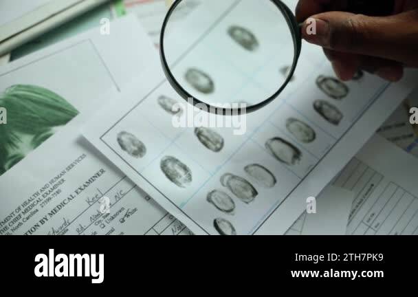 Detective investigating fingerprints with magnifying glass ...