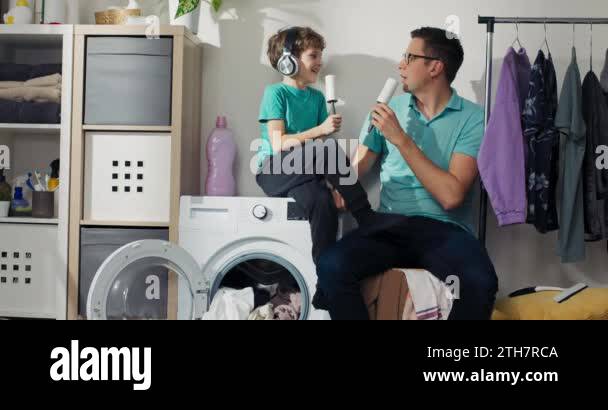 Man with glasses spends time with son in bathroom, laundry room. The ...