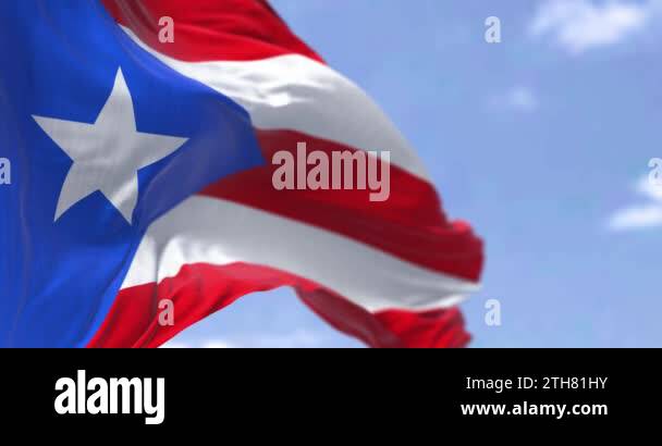 Flag of Puerto Rico waving in the wind on a clear day. Puerto Rico is a ...