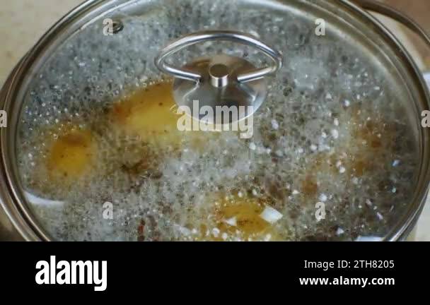 Gas home stove with potatoes boiled on it in a stainless steel saucepan ...