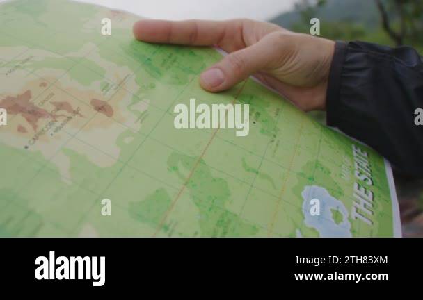 Compass and map in hands of traveler for checking and searching ...