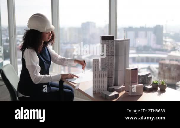 Curly female engineer working on building complex prototype project of ...