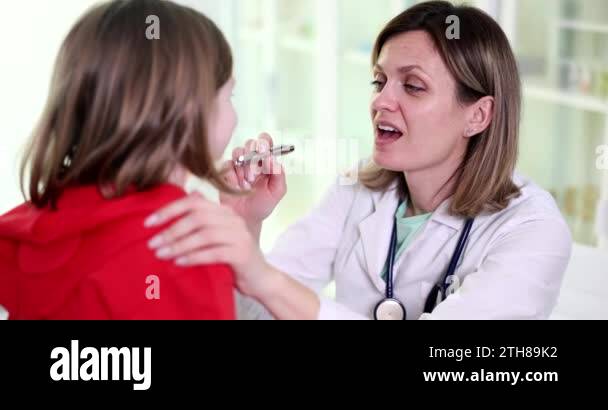 ENT doctor examines throat and mouth of little girl. Angina is ...