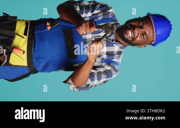 Vertical video: Young male carpenter tightening with spanner, using ...