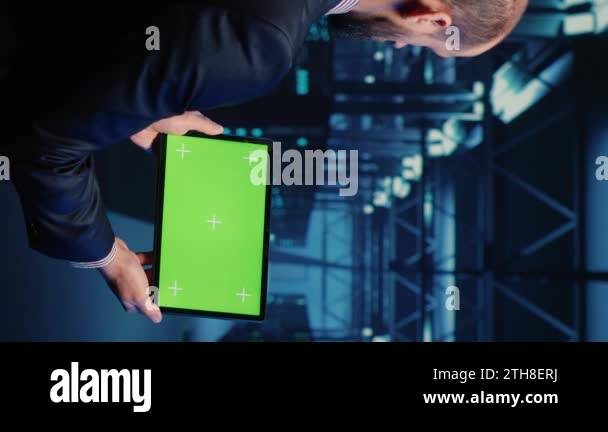 Vertical video: System engineer checking green screen display on tablet ...