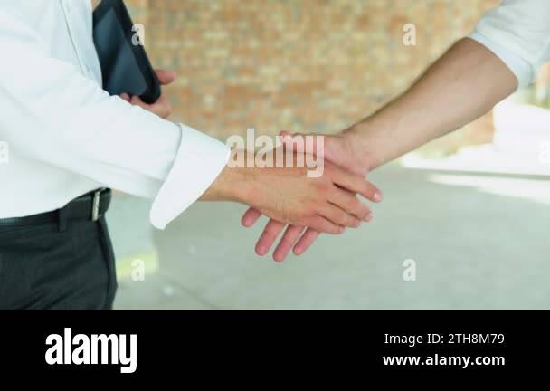 Close up of handshake in construction site. Employee or worker shake ...