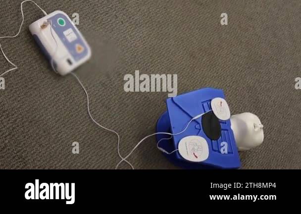 Staff is training to conduct first aid CPR with a dummy doll and AED ...