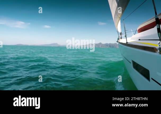 Single hull sailing yacht leisurely cruising the green waters of the ...