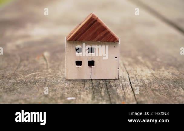 Earthquake concept. Shaking and falling wooden house model close up ...