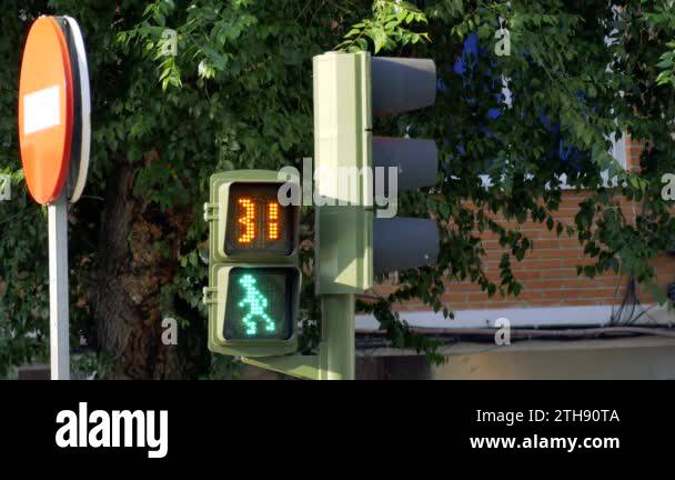 A red man figure turning green man walking figure in a traffic light ...