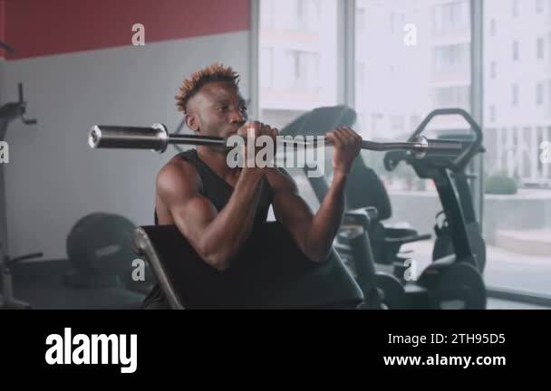 athletic african american man is lifting sports barbell in gym, workout ...