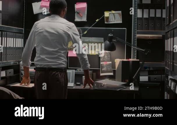 Male inspector examining forensic evidence on map, thinking about ...