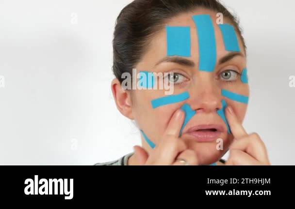 Young woman applied light blue kinesio strips taping face, forehead ...
